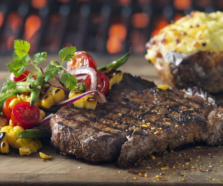 Ribeye met gepofte aardappelen, mais- en bonensalade